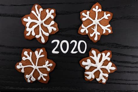 눈송이 최고 보기로 흰색 아이싱과 수제 진저 브레드 쿠키로 만든 그림 2020 과 검은 나무 배경에 크리스마스와 새해의 미니어널