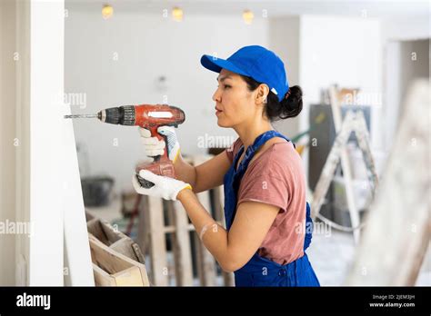 Asian Woman Construction Worker Drilling Hole In Wall Stock Photo Alamy