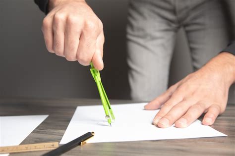 Premium Photo A Man Taking Notes With A Caliper On Paper