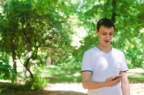 유럽 사람이 전화로 보고 하 고 웃 고 놀 랐 다 전화 의존성 소셜 네트워크 인터넷에서 작동 합니다 메시지를 작성 합니다 자연 야외입니다 화창한 날입니다 클로즈업 텍스트에