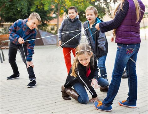 Juegos De Los Niños La Muchacha Pasa A Través De La Cuerda Enredada