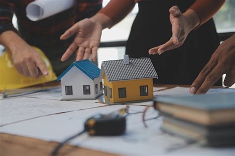 작업 현장 건설 개념에서 모델 구축 및 엔지니어링 도구에 대해 파트너와 함께 작업하는 프로젝트를 위한 청사진 회의에서 도면을 작업하는 엔지니어의 건설 및 구조 개념 개선에