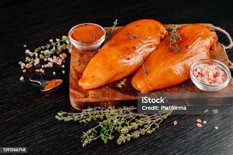 어두운 배경의 나무 부엌 보드에 빨간 소스에 생 절인 치킨 필레와 요리를위한 향신료가 있습니다 공간을 복사합니다 식이 닭고기 원료 제품 0명에 대한 스톡 사진 및 기타