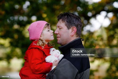 행복한 젊은 아버지는 재미 귀여운 유아 딸 가족 초상화를 함께 가을 숲이나 공원에서 아름다운 아기 소녀와 중년 남자 아빠는 야외에서 어린 아이를 안고 껴안습니다 사랑 결합