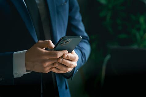 손에 휴대 전화를 가진 정장을 입은 사업가 소셜 넷을 사용하여 메시지를 입력하는 남자 뉴스 확인 비즈니스 미팅 만들기 현대적인