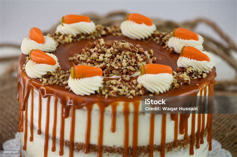 크림 치즈 프로스팅과 이슬비를 곁들인 당근 케이크 냅킨에 고립된 으깬 견과류를 곁들인 캐러멜 초콜릿 소스 고전 맛있는 케이크의 클로즈업 측면 보기 0명에 대한 스톡 사진 및