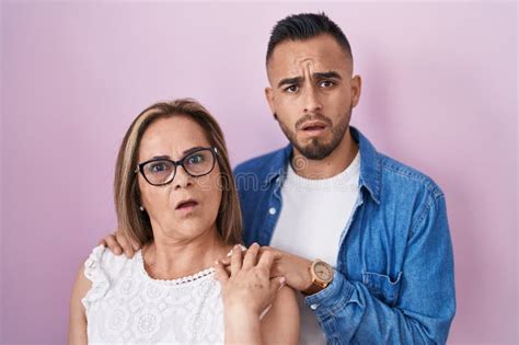 Hispanic Mother And Son Standing Together In Shock Face Looking