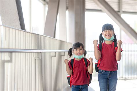 학교 배낭보호 마스크를 쓴 어린 소녀와 자매들 학교 가방을 들고 있는 초등학생의 모습 2명에 대한 스톡 사진 및 기타 이미지