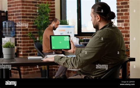 Company Employee Looking At Tablet With Horizontal Greenscreen On
