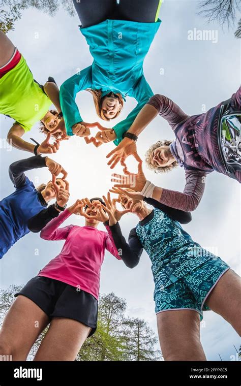 Group Of Female Athletes Runners In Circle Forming Hearts With Hands