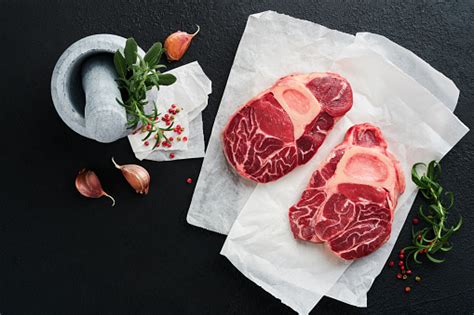 오소 부코 생 스테이크 고기 바베큐 고기 원시 신선한 크로스 컷 송아지 정강이와 조미료 후추 로즈마리 백리향 및 어두운 배경에