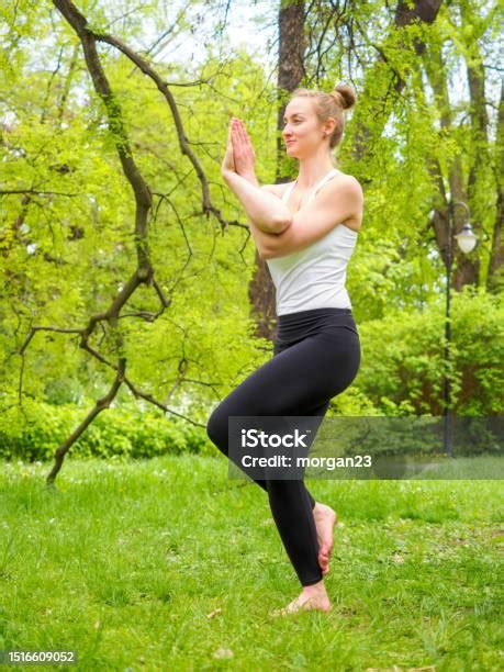 화창한 여름날 공원에서 야외 요가를 연습하는 젊은 예쁜 금발 여자 가루다아사나 포즈에 서 있다 건강한 생활방식에 대한 스톡 사진 및 기타 이미지 Istock