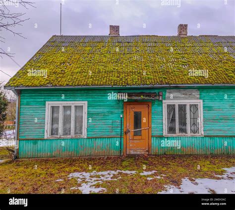 Old 20th Century Wooden House With A Mossy Roof In A Rural Field In