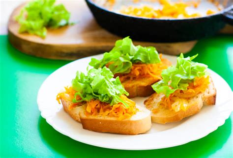 흰색 접시에 당근과 양상추를 곁들인 흰 빵 브루스케타 샌드위치 부엌 테이블의 녹색 배경에 나무 판에 프라이팬 0명에 대한 스톡 사진 및 기타 이미지 Istock