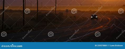 Car Driving On Road At Sunset Or Sunrise With Power Poles Stock Image