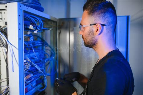 A Technician Works With Server Equipment In A Data Center A Man