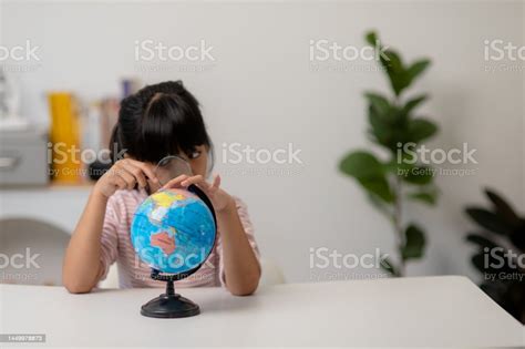 아시아 어린 소녀는 세계 모델 세상을 구하고 집에서 어린이 교육을위한 놀이 활동을 통해 배우는 개념을 배우고 있습니다 세계지도에