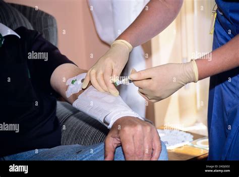 Intravenous Drug Injection Close Up Of A Community Rgn Registered General Nurse On A Home