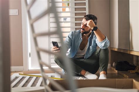 남자는 아기 침대를 조립하는 그를 돕기 위해 전화로 사람을 호출합니다 가구에 대한 스톡 사진 및 기타 이미지 가구 가족 교습 Istock