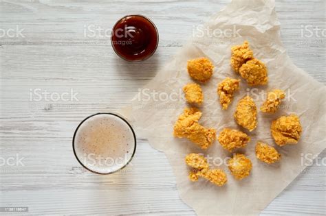치킨에 물린 바베 큐 소스와 흰색 나무 표면에 맥주의 유리 평면도 평평한 평 신도 오버 헤드 위에서 0명에 대한 스톡 사진 및