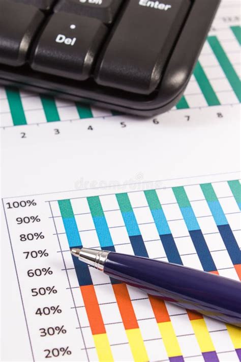 Ballpen Computer Keyboard And Financial Chart Showing Production Or