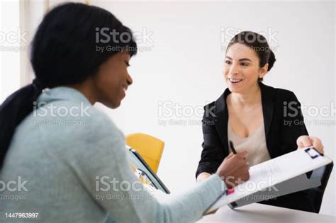 사무실 책상에 앉아 고객에게 계약서를 보여주고 설명하는 웃는 사업가 여성 서명 20 24세에 대한 스톡 사진 및 기타 이미지 20 24세 25 29세 2명 Istock