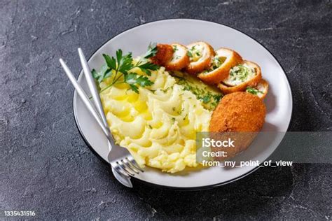 치킨 키예프 부스러기와 튀긴 닭 가슴살을 녹는 마늘 버터로 박제 콘크리트 테이블에 접시에 으깬 감자와 함께 제공 위에서 수평