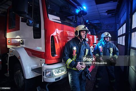 소방차 차고에서 소방차 옆에 서 있는 보호복을 입은 소방관 2명 구명 기구에 대한 스톡 사진 및 기타 이미지 구명 기구