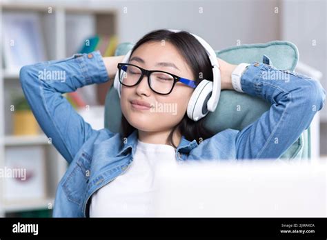 Young Beautiful Asian Woman Listening To Music In Headphones Closing