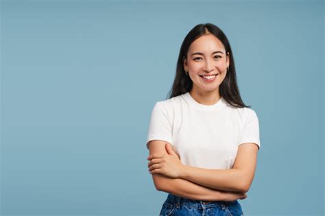 팔짱을 끼고 포즈를 취하는 웃는 아시아 여성이 파란색 배경에 카메라를 보고 있습니다 여자에 대한 스톡 사진 및 기타 이미지 여자 미소 인물 사진 Istock