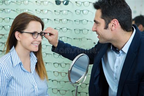 Male Optician Checking Fit Glasses On Female Customer Stock Image
