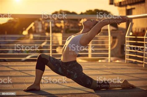아름 다운 젊은 여자 관행 요가 아사 나 Virabhadrasana 1전사 일몰 테라스에서 1 포즈 가냘픈에 대한 스톡 사진 및 기타 이미지 Istock