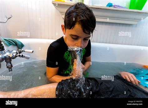 Twin Caucasian Brothers Play In Their Water Filled Bathtub Together