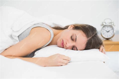 커버 아래 그녀의 침대에 누워 귀여운 잠자는 여자 프리미엄 사진