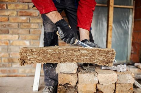 Premium Photo Close Up Of A Housebuilder Cutting Insulation On A