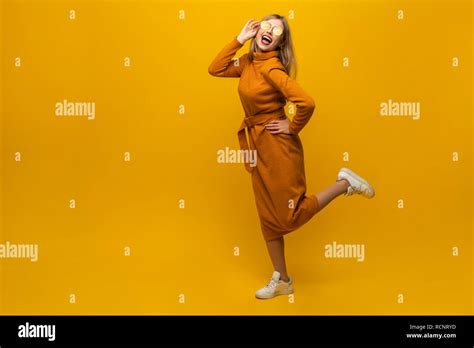 Full Length Portrait Of A Cheerful Beautiful Girl Wearing Dress Having