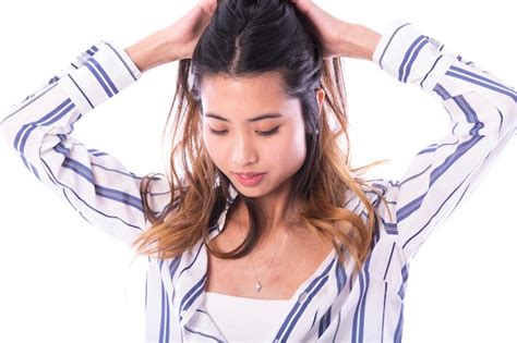 Mão de uma mulher segurando seu cabelo comprido olhando para pontas