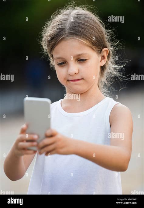 Portrait Of Serious Pretty Girl In Elementary School Age Looking At