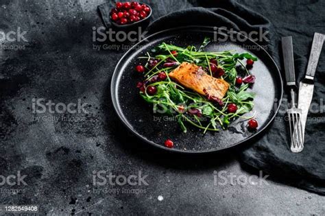 연어 아루굴라 양상추 크랜베리를 곁들인 해산물 샐러드 검은 색 배경 맨 위 보기입니다 복사 공간 건강한 식생활에 대한 스톡 사진