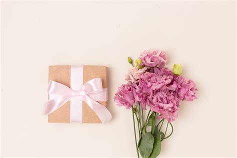 베이지 색 배경에 유스토마 꽃의 꽃다발과 묶인 활이있는 선물 상자 0명에 대한 스톡 사진 및 기타 이미지 0명 갈색 용지