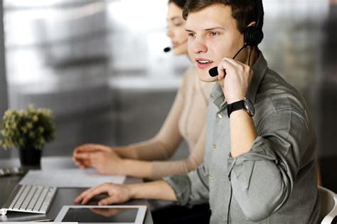 웃는 젊은 사업가와 프로그래머는 현대적인 사무실에 함께 앉아 컴퓨터에서 일부 데이터를 확인하고 있습니다 사람에게 집중하십시오 성공적인 창업의 개념 20 24세에 대한 스톡