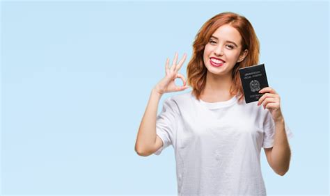 손가락 우수한 기호 확인 서명 하 고 격리 된 배경 위에 이탈리아의 패스포트를 들고 젊은 아름 다운 여자 개념에 대한 스톡 사진