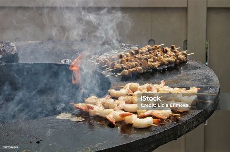 해산물 조각은 원뿔 모양의 그릇 모양으로 화덕 표면에서 조리됩니다 새우와 새우를 곁들인 그릇 모양의 납작한 그릴 야외 바베큐