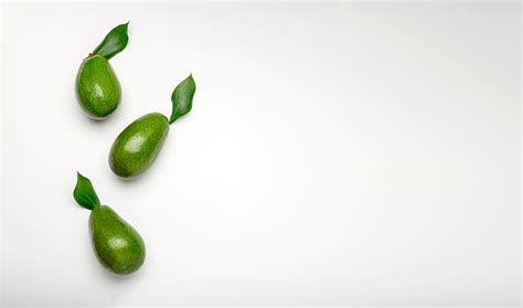 신선한 잘 익은 유기농 녹색 아보카도와 흰색 배경에 잎이있는 반쪽 텍스트복사 공간이있는 여름 음식 개념을 볼 수 있습니다 노란색 배경 긴 배너에 최소 플랫 평신도 스타일의