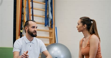 물리 치료사와 운동 여성은 헬스 클럽에서 바닥에 앉아 이야기합니다 공간을 복사합니다 사진 Unsplash의 세르비아 이미지