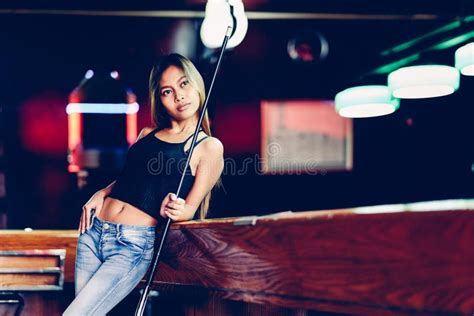 Young Beautiful Girl In A Billiard Club With Cue Stick Posing Stock