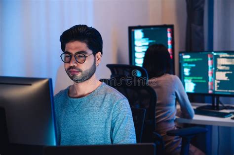 Asian Software Developers Working On Multiple Screens Displaying Code And Application Diagrams