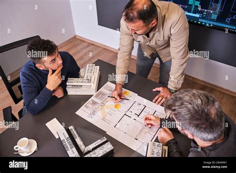 Group Of Engineers Meeting In Boardroom Team Leader Man Presenting Ideas On Whiteboard