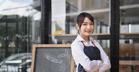 웃고 있는 젊은 여자가 커피숍 입구에 팔짱을 끼고 서 있다 사진 Unsplash의 태국 이미지