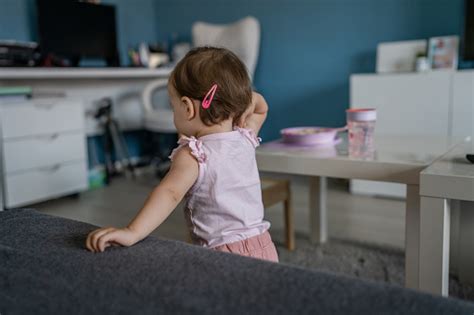 한 소녀의 뒷모습 작은 유아 아기 백인 아이가 방 절반 길이 복사 공간에서 집에 서거나 걷고 있습니다 12 17 개월에 대한